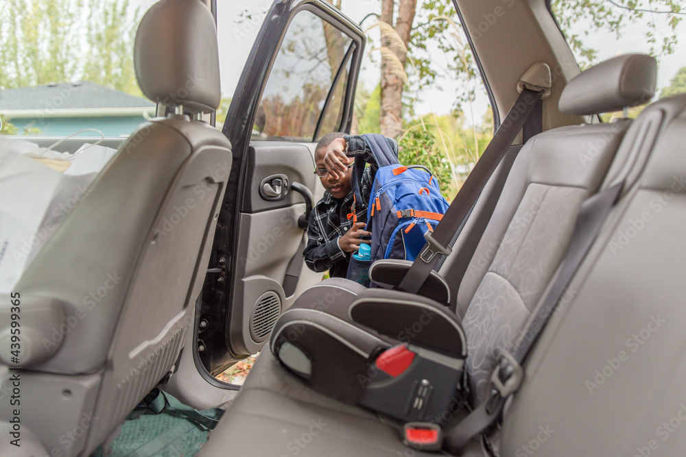 Student loads backpack into vehicle Stock Photo | Adobe Stock