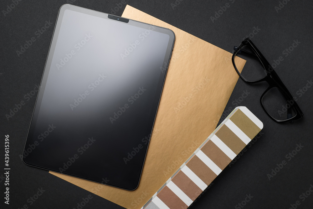 Сatalog of gold colors, an electronic tablet, glasses, and a gold leaf ...