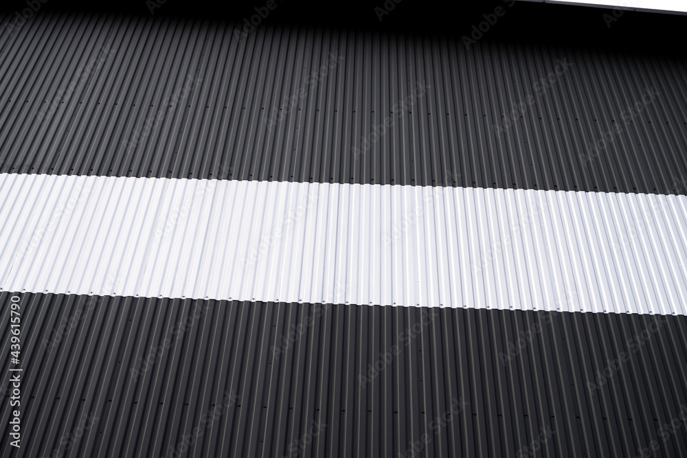 Black and white corrugated iron sheet used as a facade of a warehouse ...