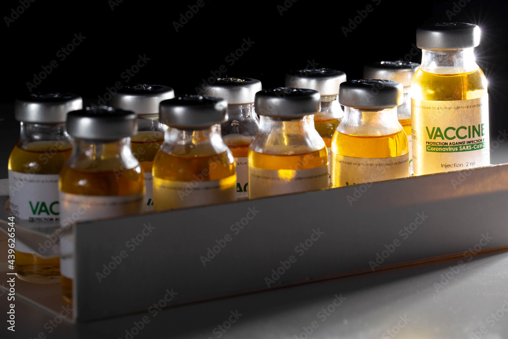 Vials with coronavirus vaccine in packaging on a black background and ...
