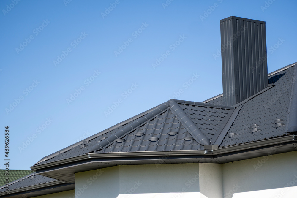 Grey corrugated metal profile roof installed on a modern house. The ...