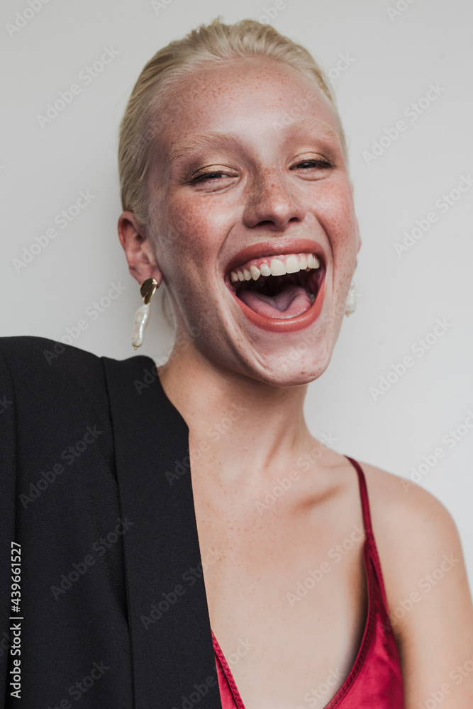 Fashion model laughing hard while wearing red top, black blazer and ...
