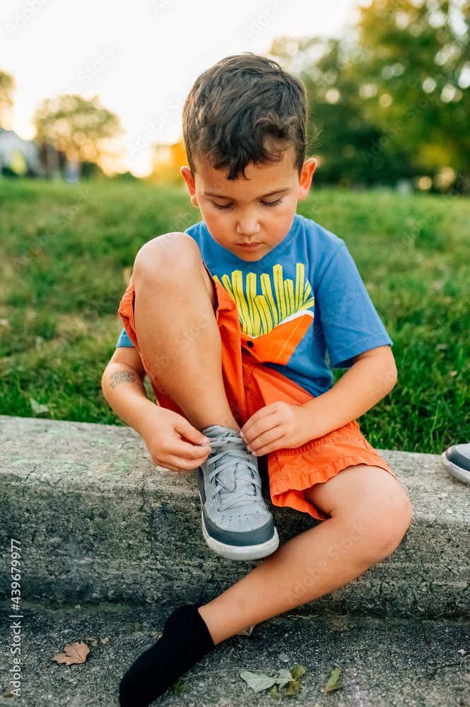 Boy learning to tie shoes. Stock Photo | Adobe Stock