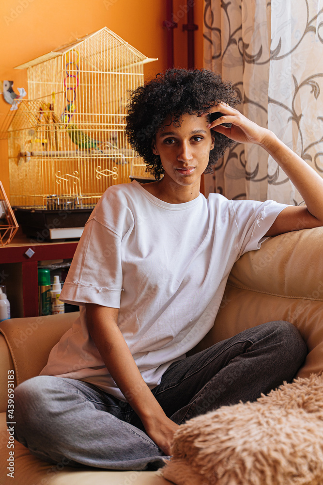 young black woman sitting on the couch at home Stock Photo | Adobe Stock