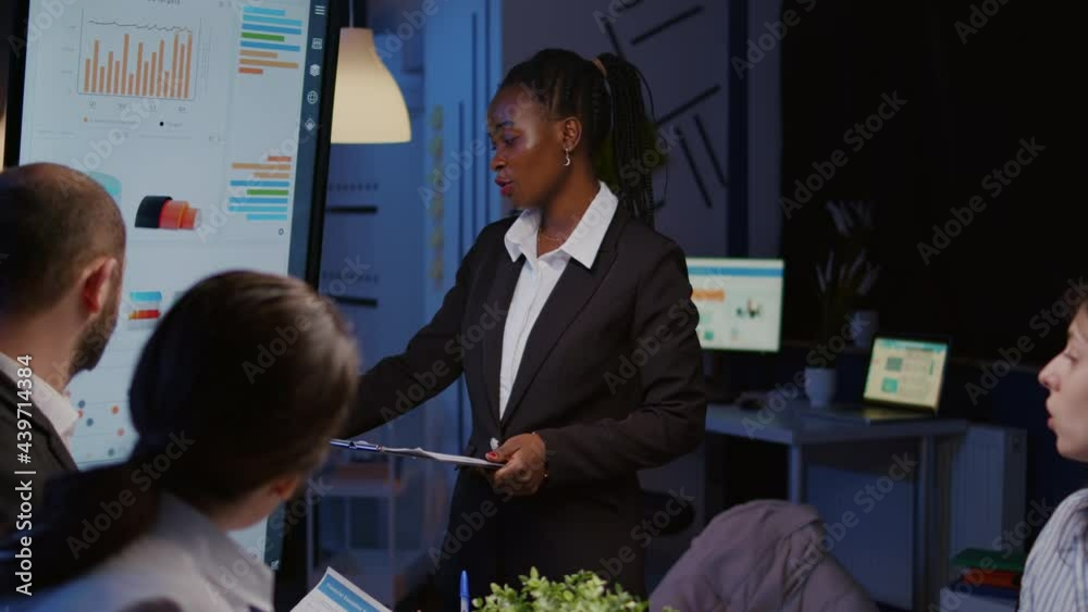 Workaholic african american leader standing in front of presentation ...