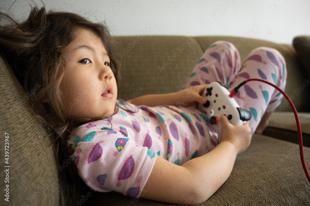 Little girl playing video game Stock Photo | Adobe Stock