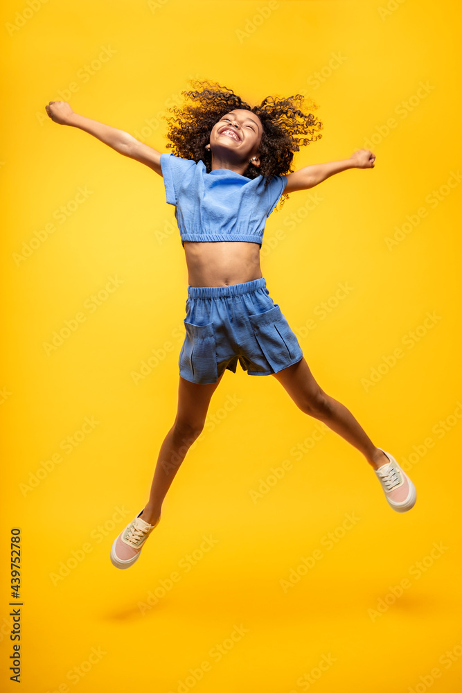 Black kid jumping in studio smiling. Stock Photo | Adobe Stock