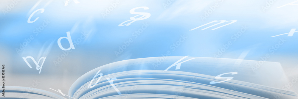 Open books have floating English letters on wood table. And blurred ...