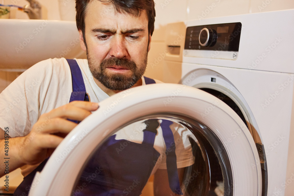 Plumber repairs broken clothes dryer Stock Photo | Adobe Stock