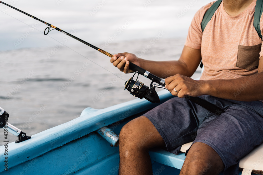 Fisherman On Boat Pulling Fishing Rod Stock Photo | Adobe Stock