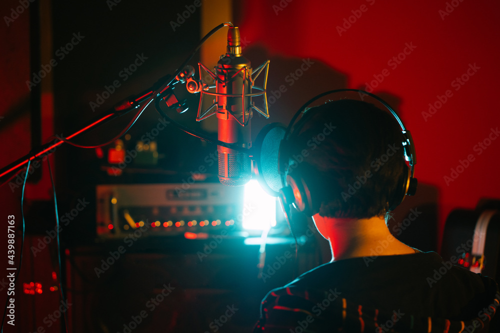 Back view of vocalist singing into professional microphone in recording ...