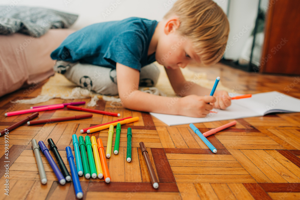 Kid using colored markers to make drawings Stock Photo | Adobe Stock