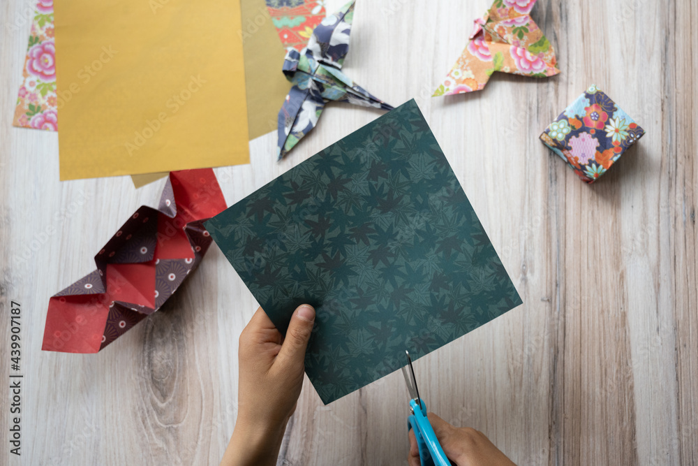 Child cutting origami paper Stock Photo | Adobe Stock