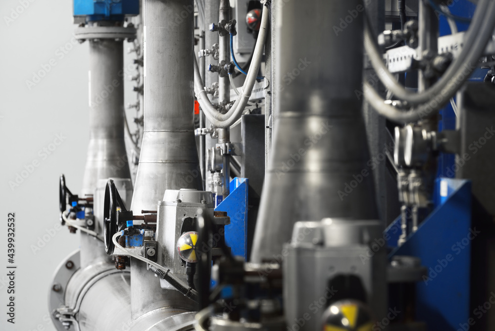 Industrial water treatment and boiler room. Shiny steel metal pipes ...