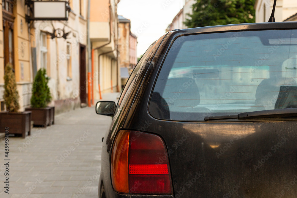 Back window of black car parked on the street in summer sunny day, rear ...
