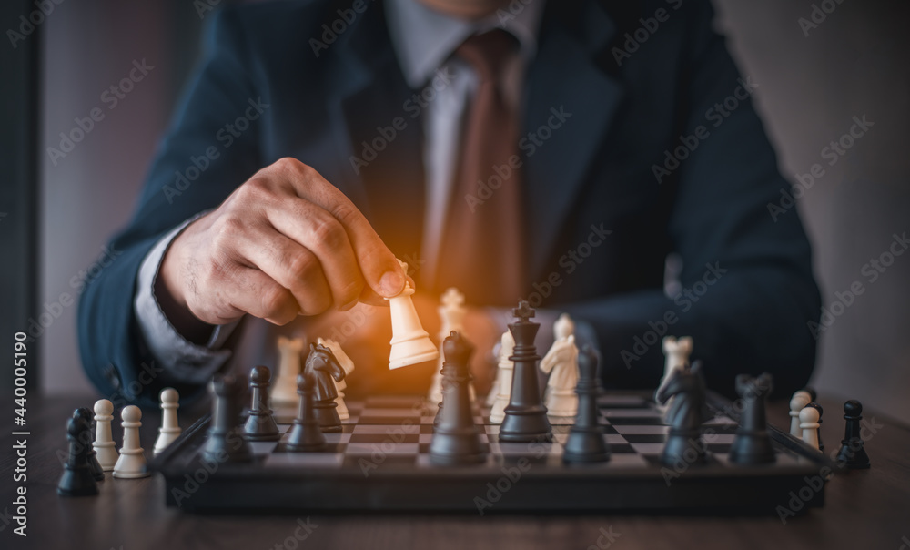 Businessman play chess board game. A white chess team and black chess ...