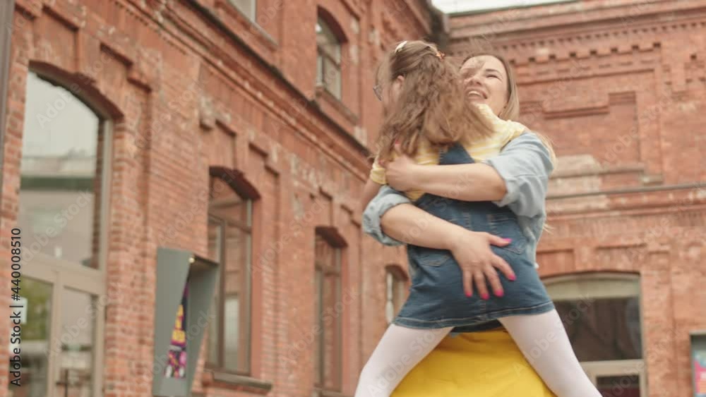 Medium slowmo of pretty 11-year-old girl running to loving mother ...