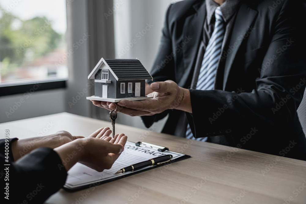 The salesperson handed the small gray model of the house and the house ...