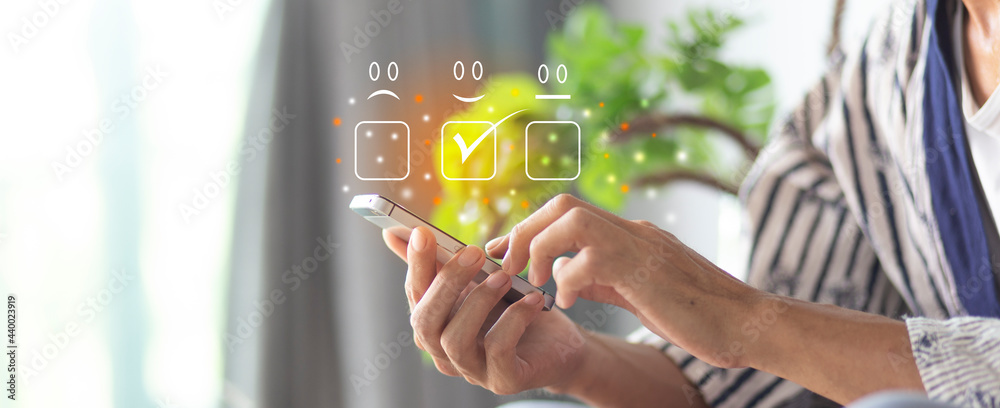 hand of customer pressing on smartphone with smiling face icon for ...