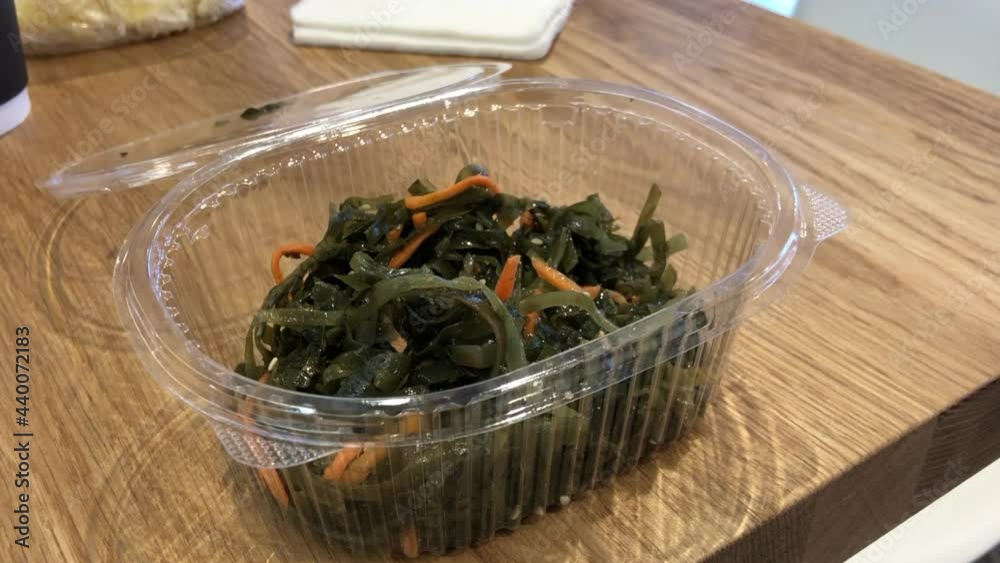 Seaweed salad with carrots in a plastic disposable container at a fast ...