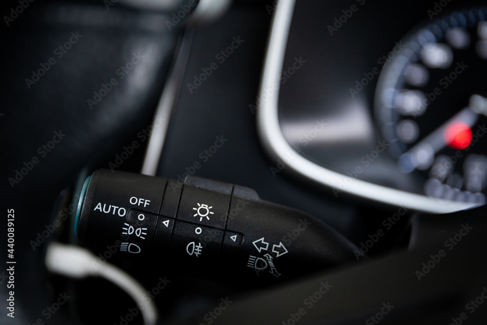 Modern headlight switch in the modern car cockpit close up with ...