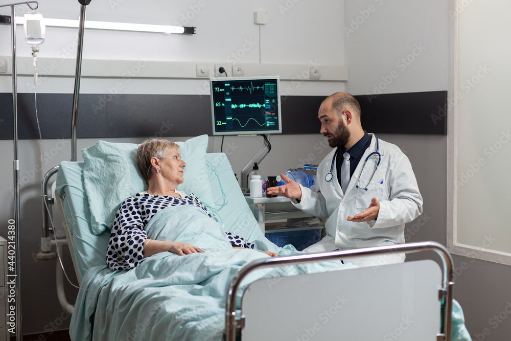 Senior woman laying in bed inhale and exhale with help from oxygen tube ...