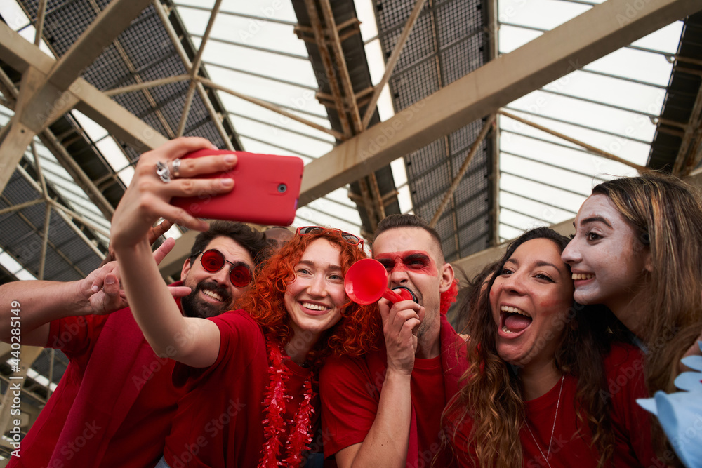 Group of fans take selfie while cheering for their sports team from a ...