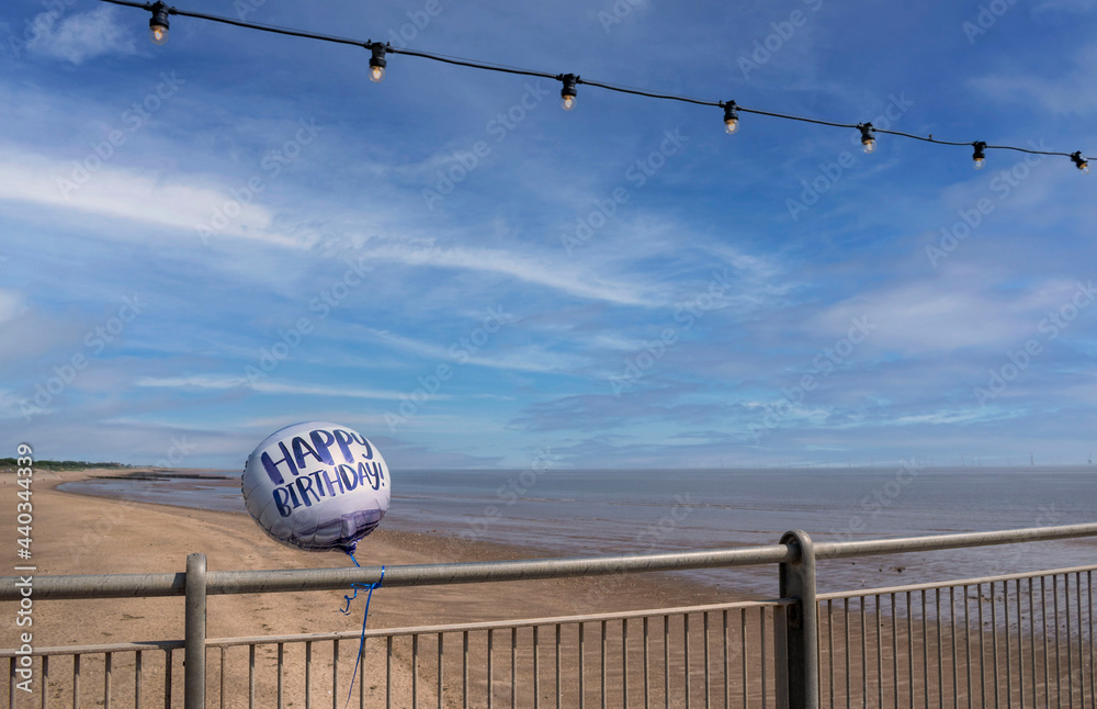Happy birthday balloon tied to the fence of the Skegness beach pier ...