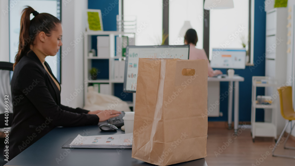 Businesswoman holding paper bag with takeaway food meal order putting ...