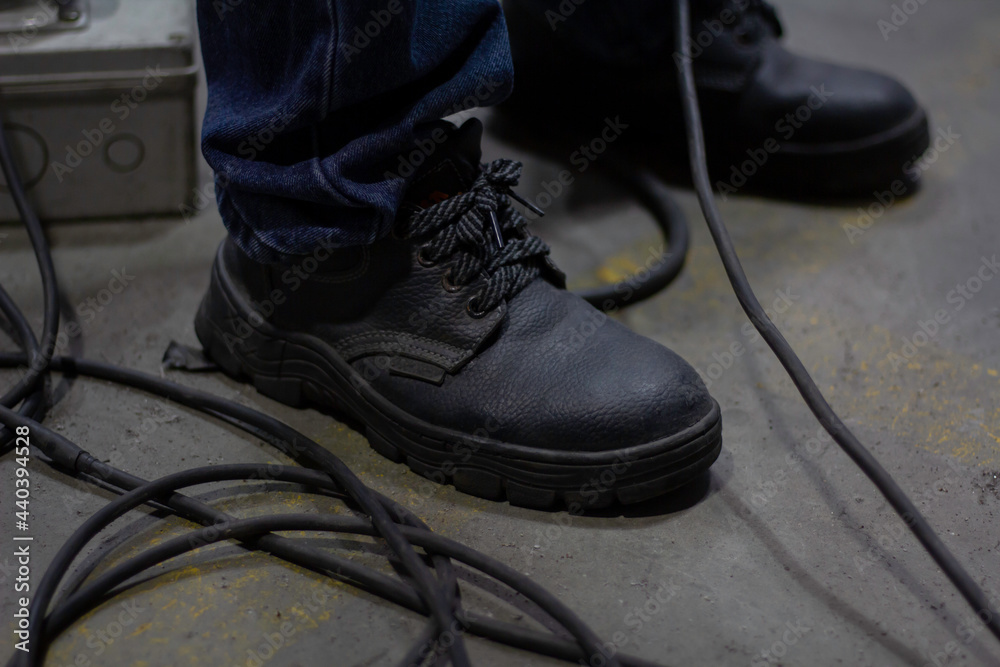Wear safety shoes to ensure safety at work. construction workers wear ...