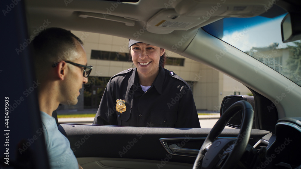 Friendly police officer checking driver license of man Stock Photo ...