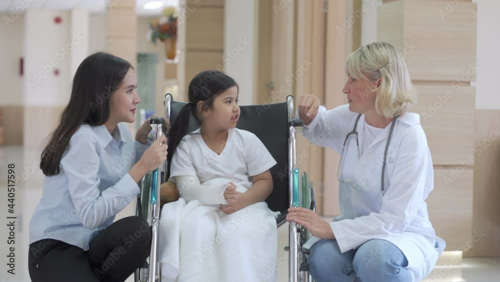 Female pediatrician doctor and child patient on a wheelchair with her ...