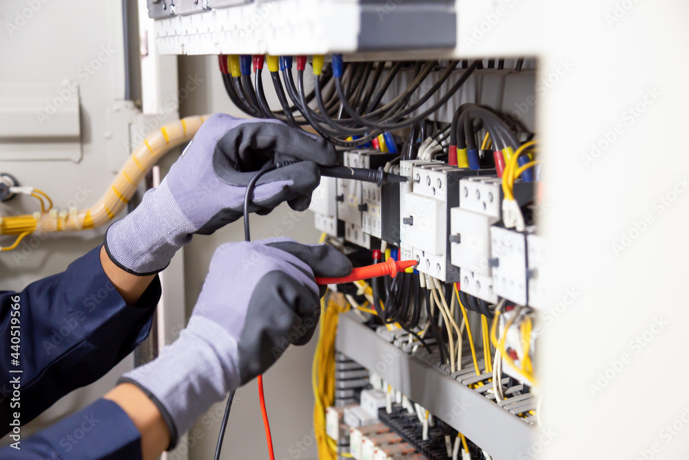Electrician engineer tests electrical installations and wires on relay ...