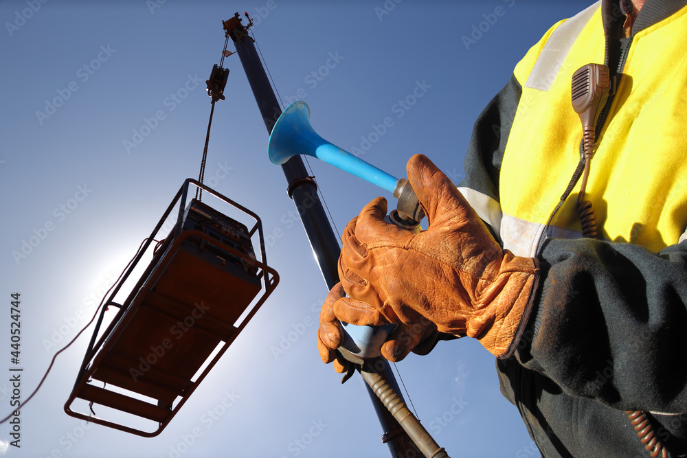 Trained competent rigger hand wearing a safety leather glove using air ...