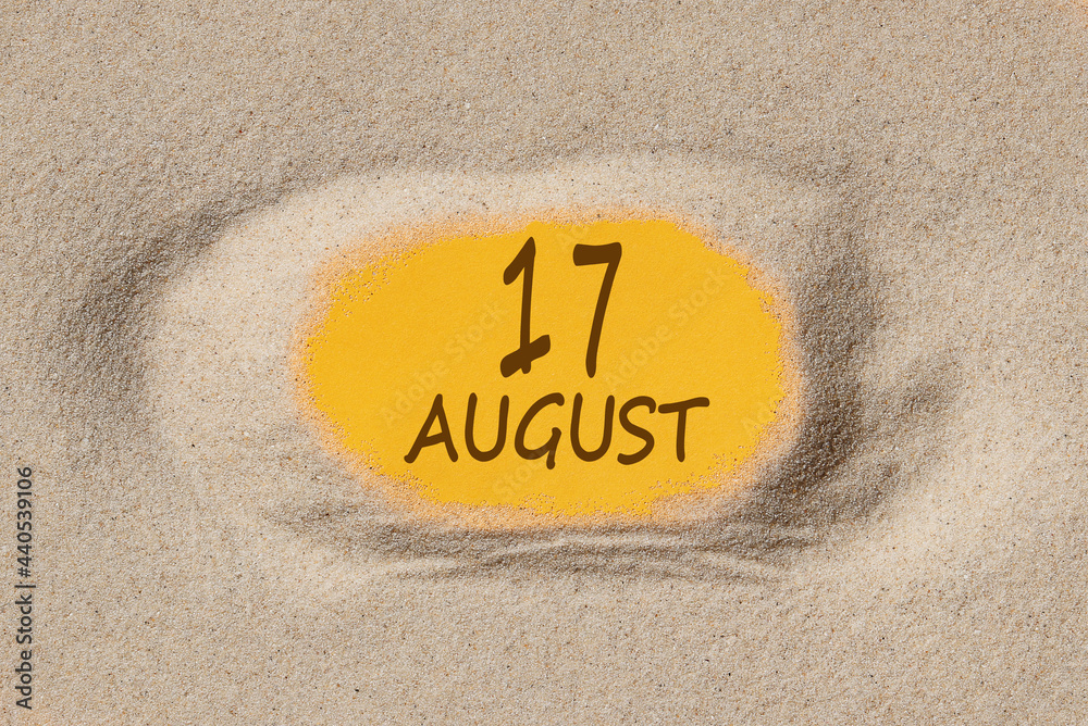 August 17. 17th day of the month, calendar date. Hole in sand. Yellow ...