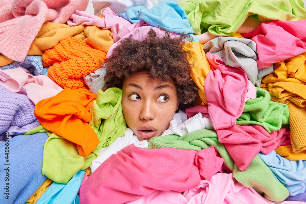 Woman head sticking out through different multicolored clothes looks ...