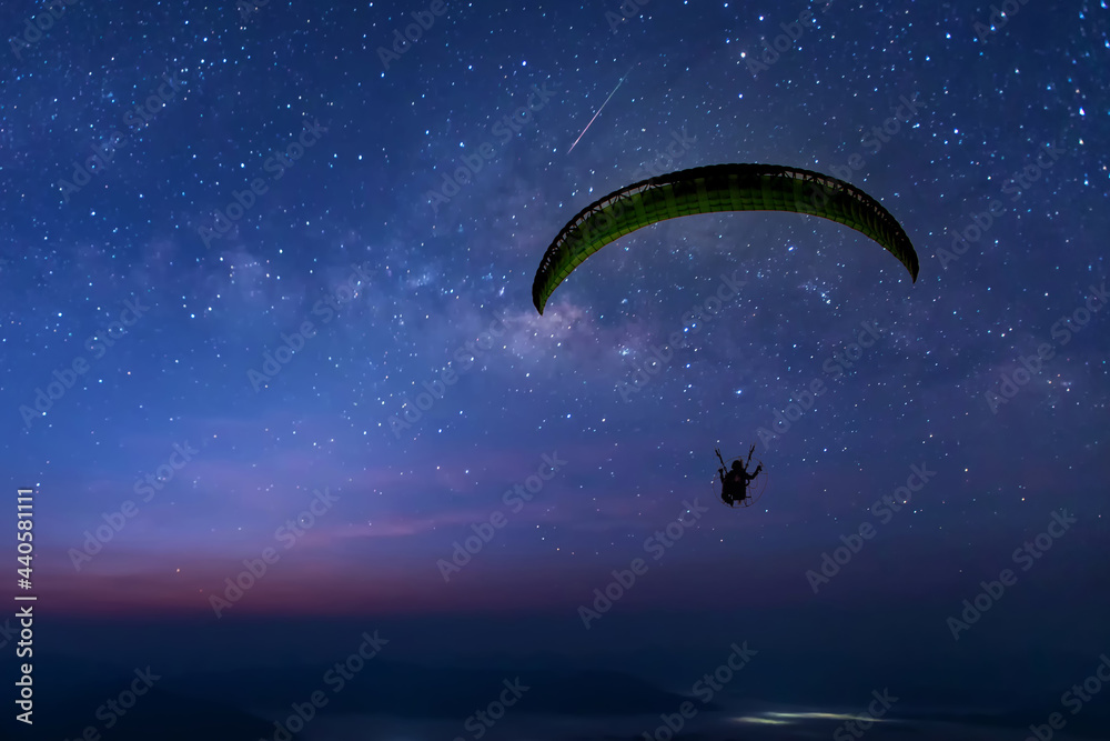 Skydiving night landscape of parachutist flying in soft focus. Para ...