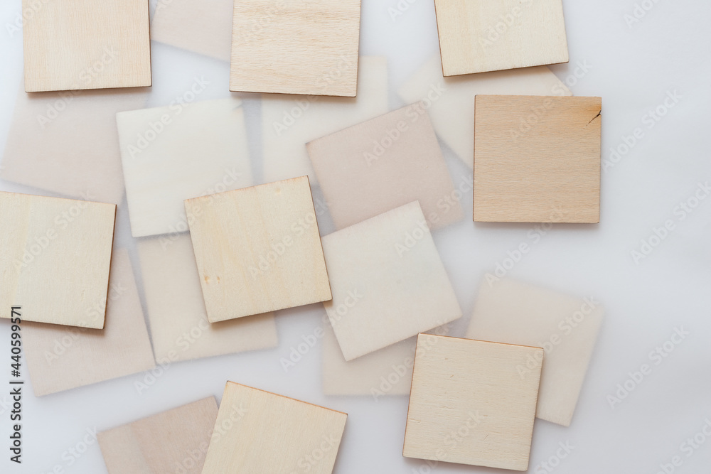 laser cut untreated or natural square wooden shapes arranged on a light ...