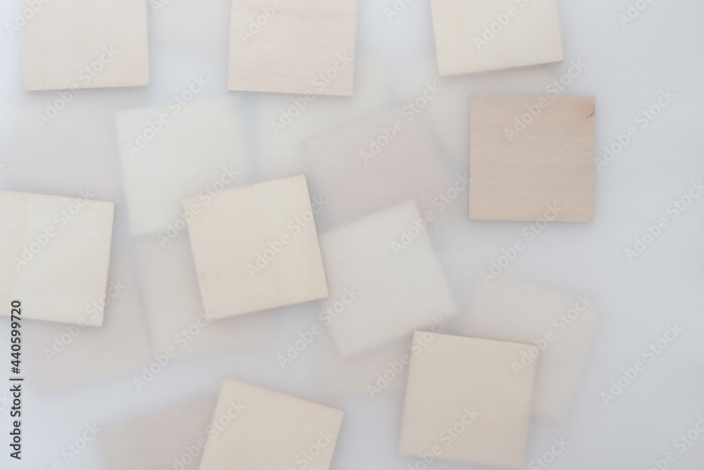 laser cut untreated or natural square wooden shapes arranged on a light ...