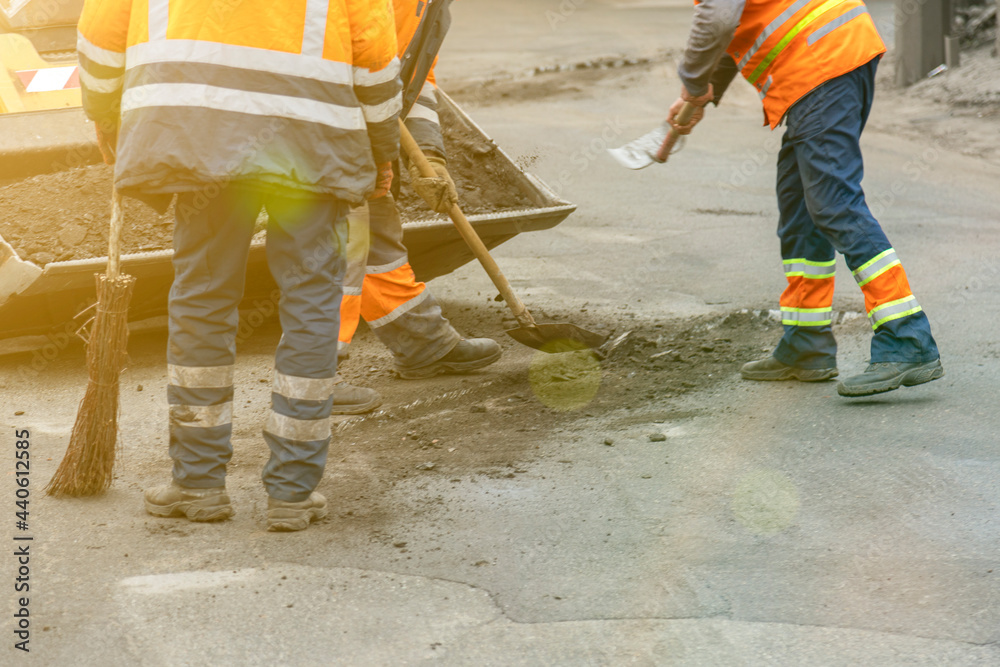 Foto Stock Road workers in bright orange reflective uniforms use ...