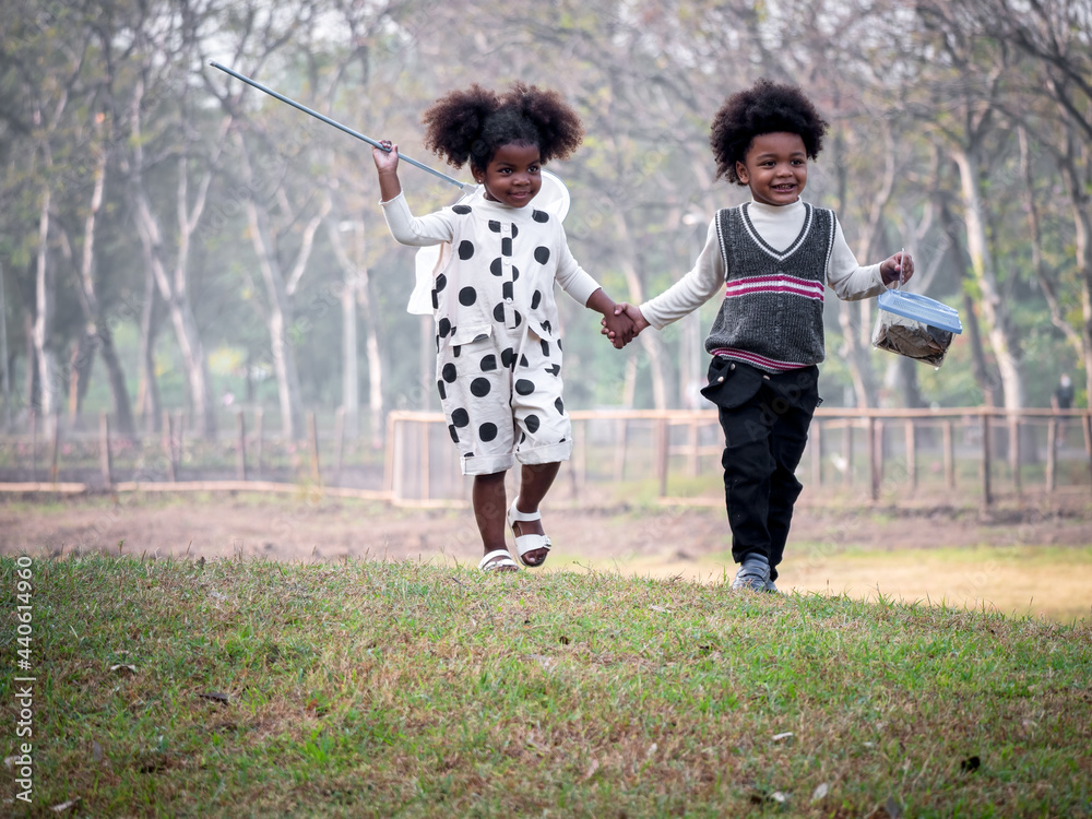 African American boys and girls catch insects in the forest on ...