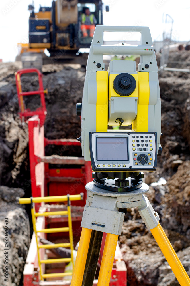 Yellow equipment set out on tripod on building site against cloudless ...