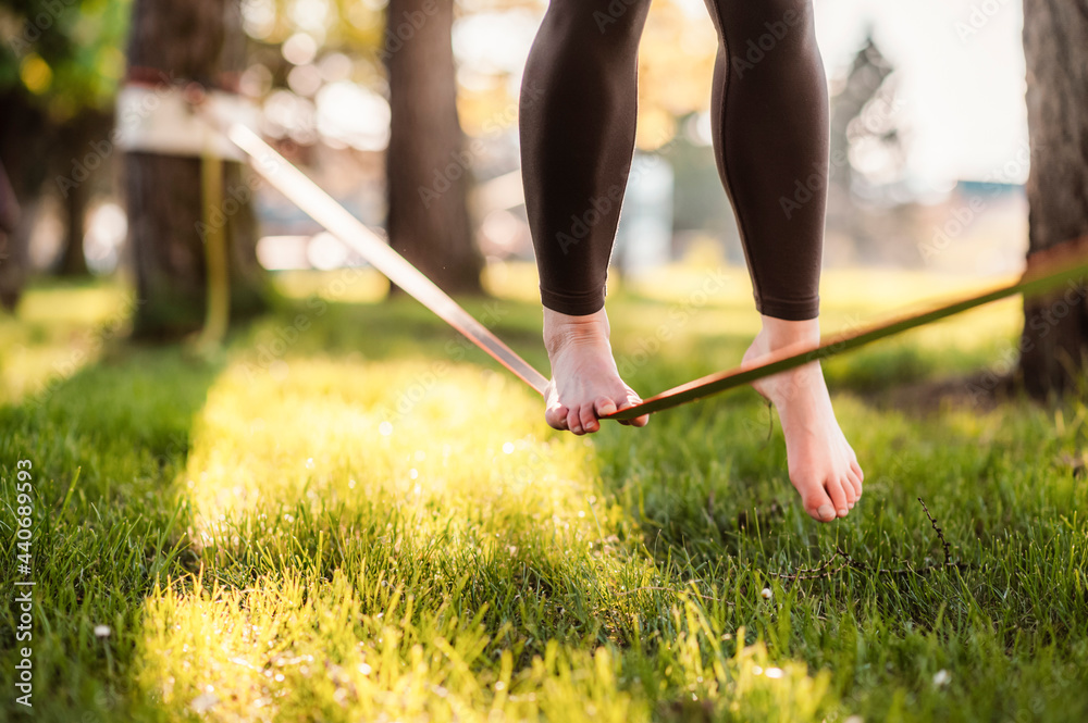 Slacklining is a practice in balance that typically uses nylon or ...