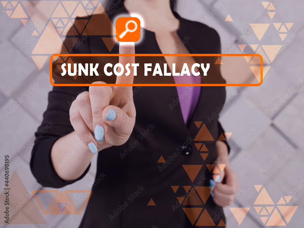 SUNK COST FALLACY inscription on the screen. Businessman hands holding ...