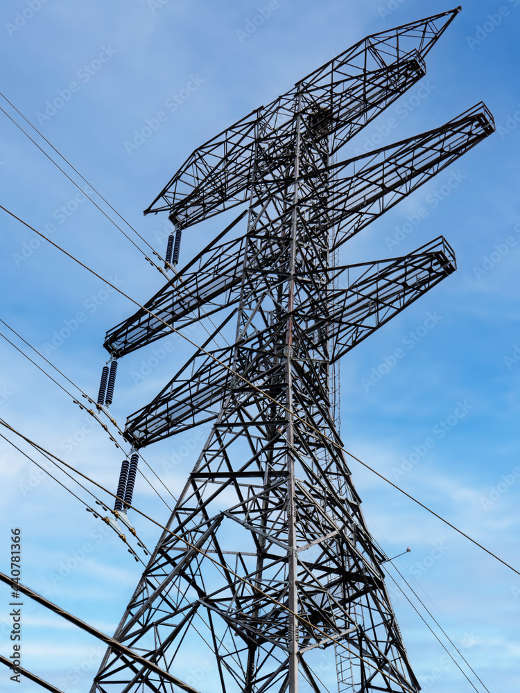 Massive steel tower is part of electrical grid supporting high voltage ...