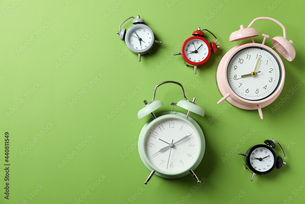 Different multicolor alarm clocks on green background Stock Photo ...