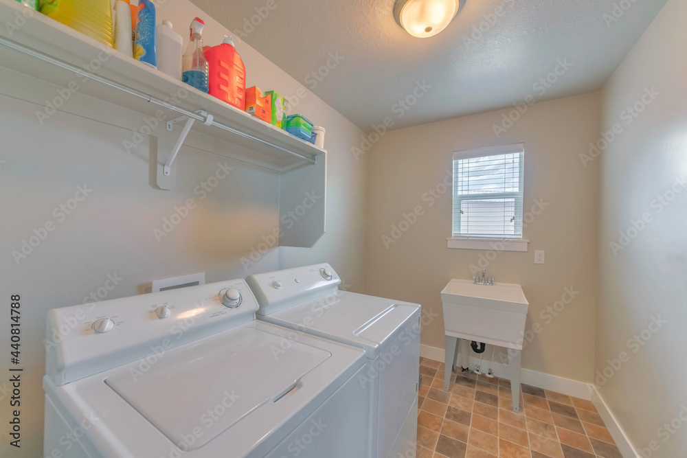Laundry room with a washing machine, a dryer, and wooden cabinets for ...