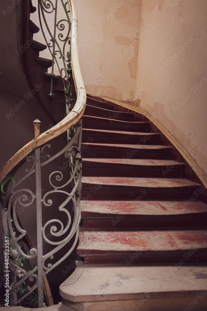 Vintage wooden staircase with iron rail. Old circular stairway in ...