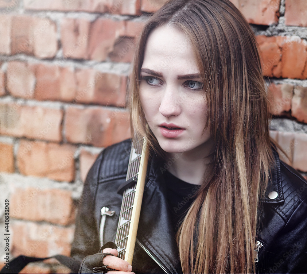 Beautiful young girl rocker with electric guitar. A rock musician girl ...