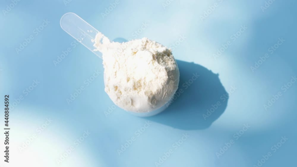 Protein powder in a scoop on blue background with highlights. Stock ビデオ ...